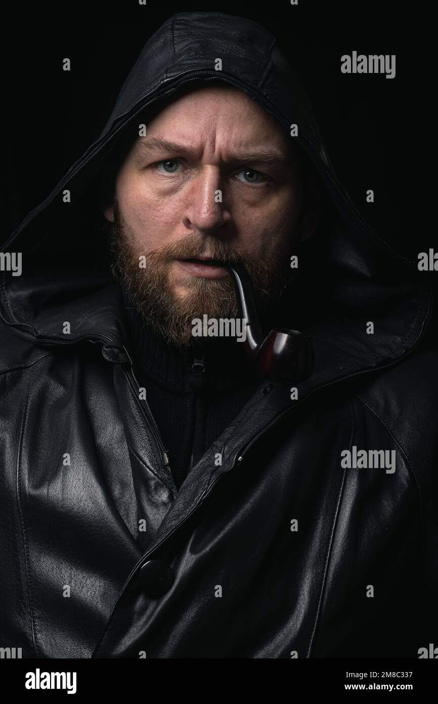 Portrait of a Bearded man in Black Rain Jacket Smoking a Pipe Stock ...