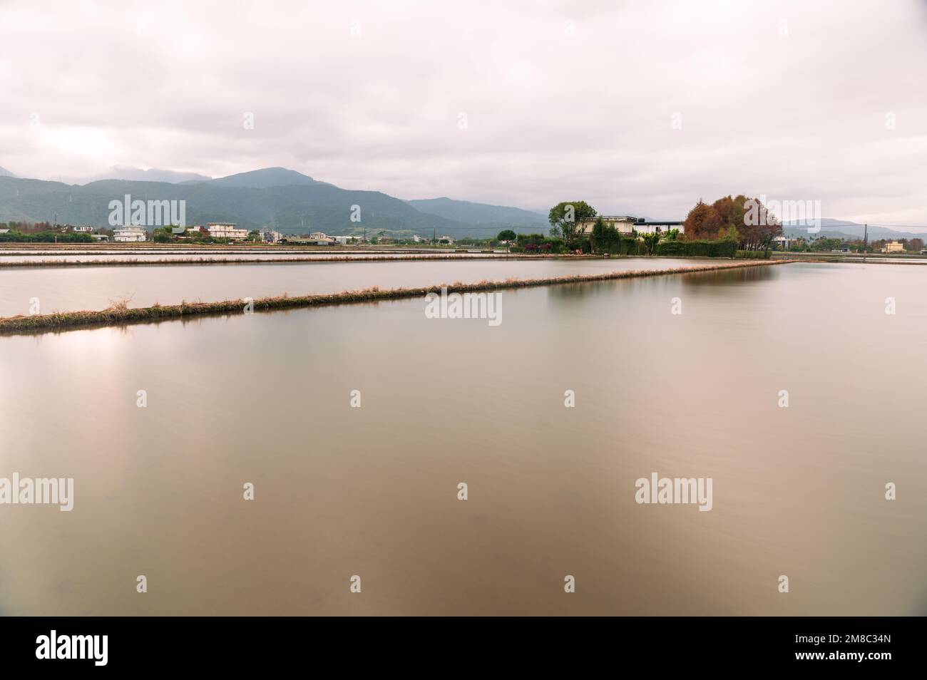 Beautiful countryside landscape at dusk. House, water field and ...