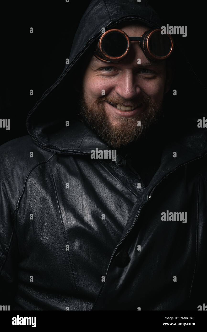 A man in a hood, wearing vintage steampunk goggles looking at the ...