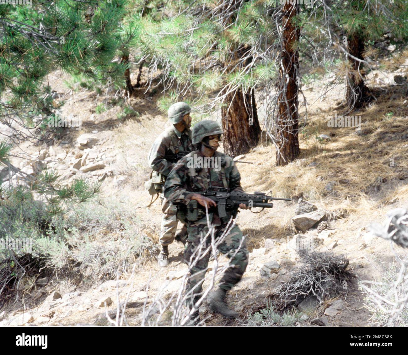 Two Marines, one carrying an M-16A2 rifle equipped with an M-203 ...