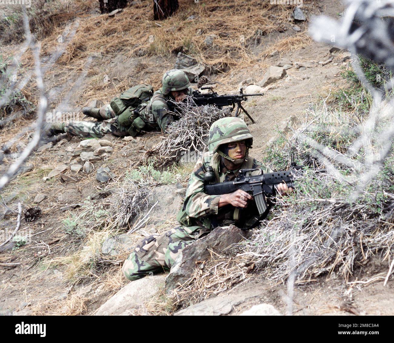 Two Marines, one with an M-16A2 rifle, the other with an M-249 Squad ...