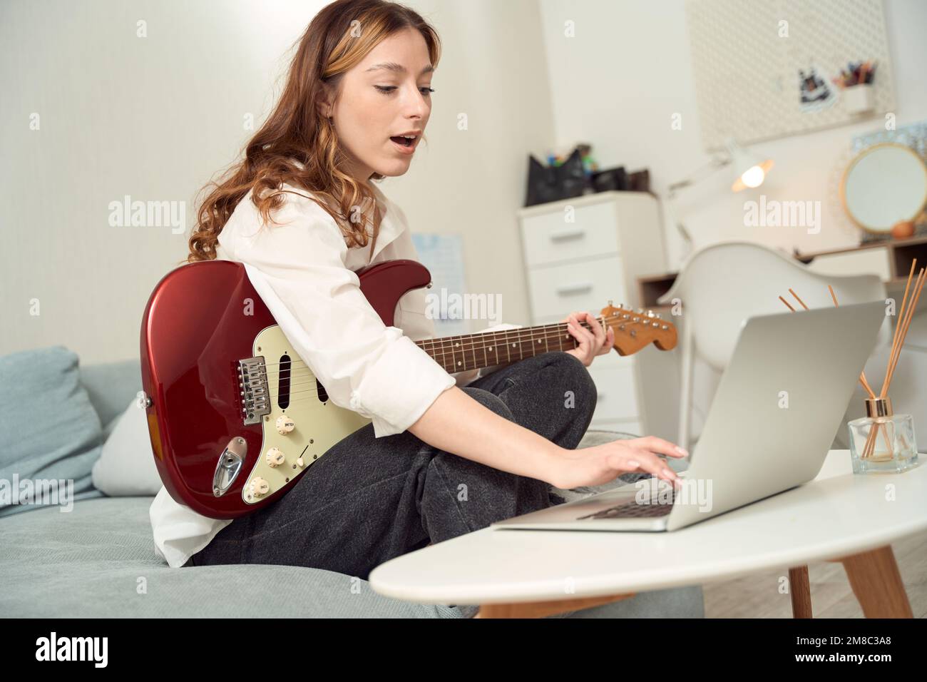 Focused female musician preparing to play stringed instrument Stock ...