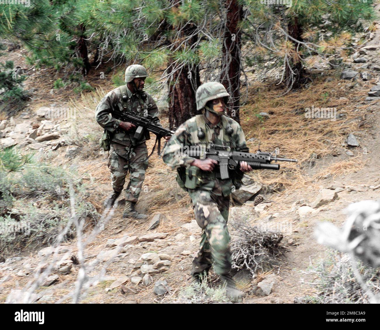 Two Marines, one with an M-16A2 rifle equipped with an M-203 grenade ...