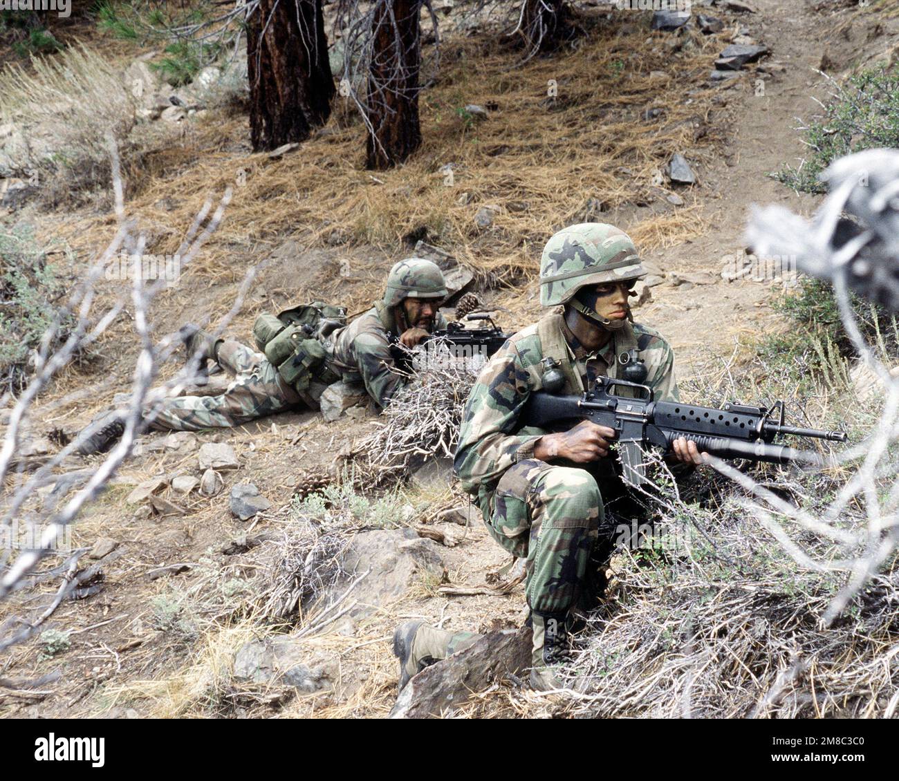 Two Marines, one with an M-16A2 rifle equipped with an M-203 grenade ...