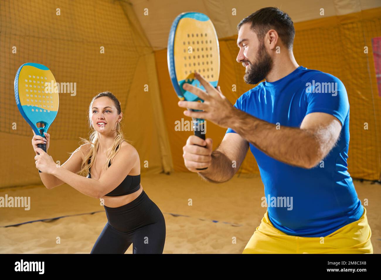 Coach watching woman holding tennis racket in frescoball hall Stock ...
