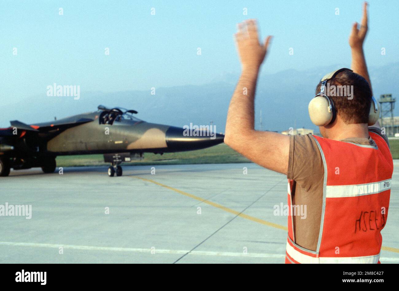 A member of the 42nd Aircraft Maintenance Unit signals to the pilot of ...