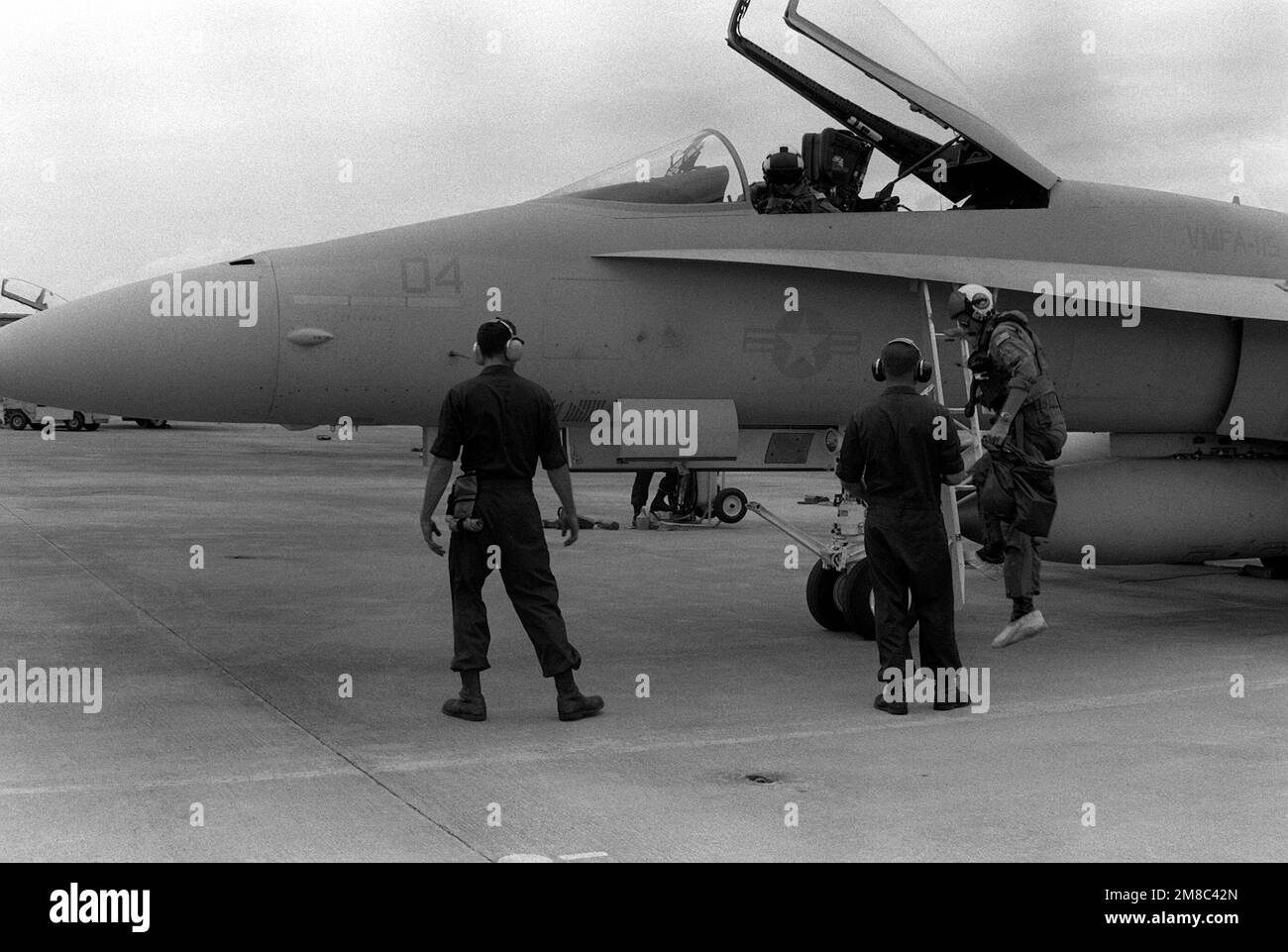 A pilot climbs down from a Marine Fighter Attack Squadron 115 (VMFA-115 ...