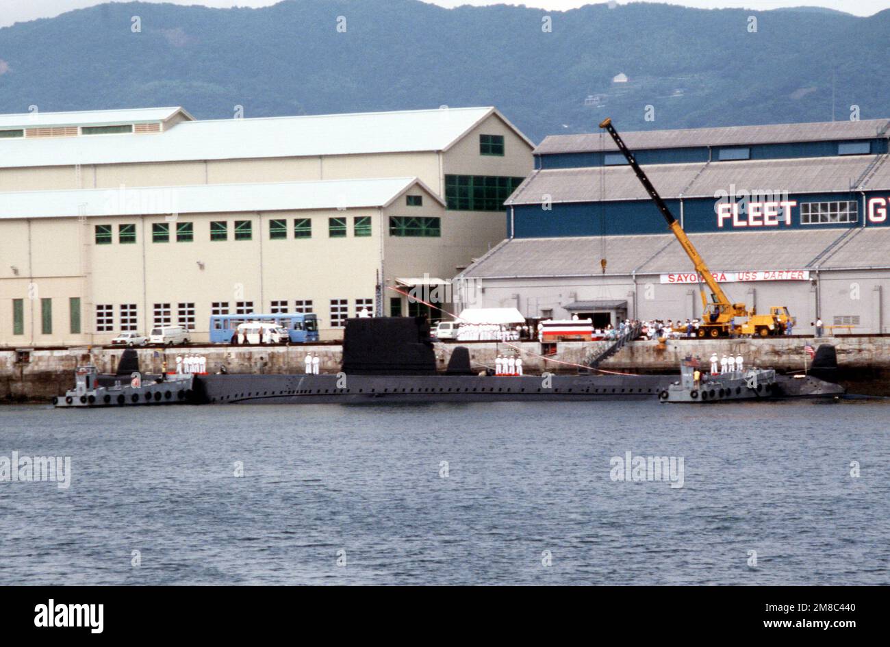 Crew members stand atop the attack submarine USS DARTER (SS 576) while ...