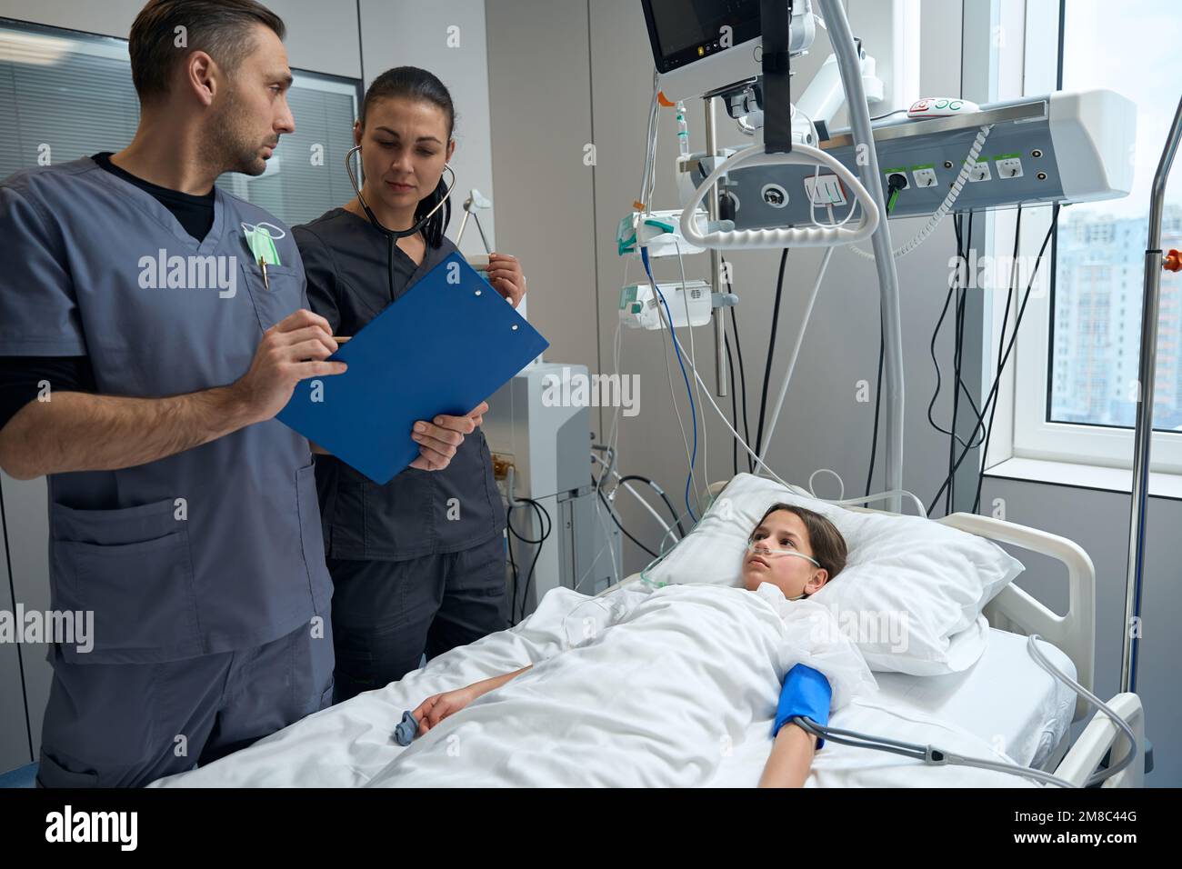 Nurses checking health of young lady in clinic Stock Photo - Alamy