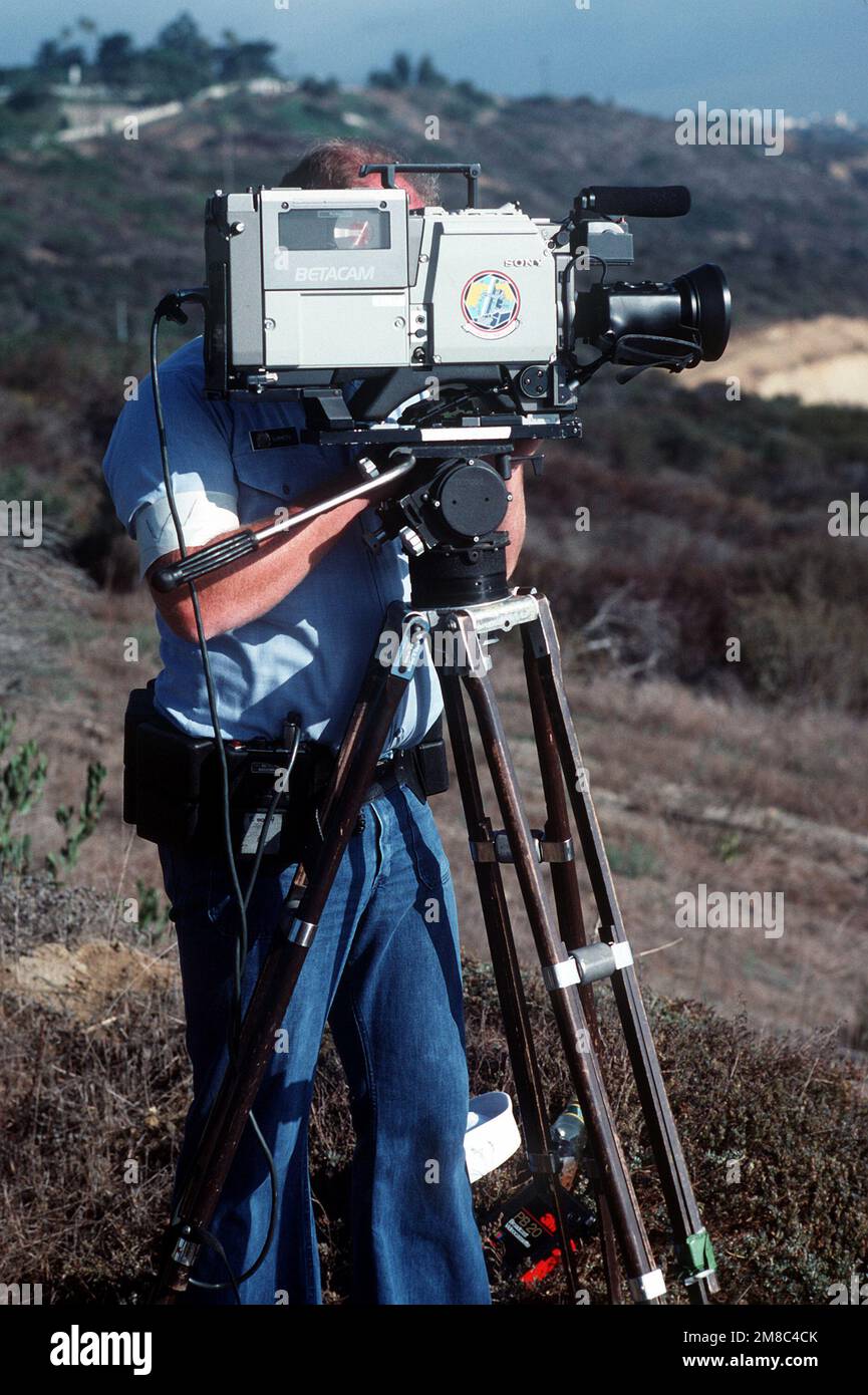 A video cameraman from Fleet Imaging Command, Pacific, films ships that ...