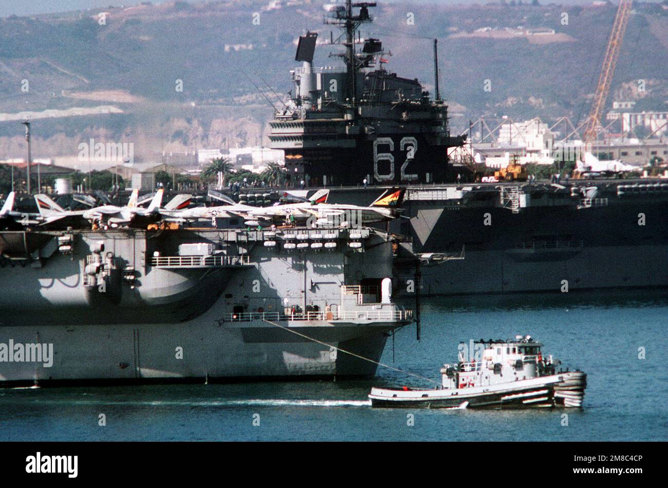 The large harbor tug Canonchet (YTB-823) pulls the aircraft carrier USS ...