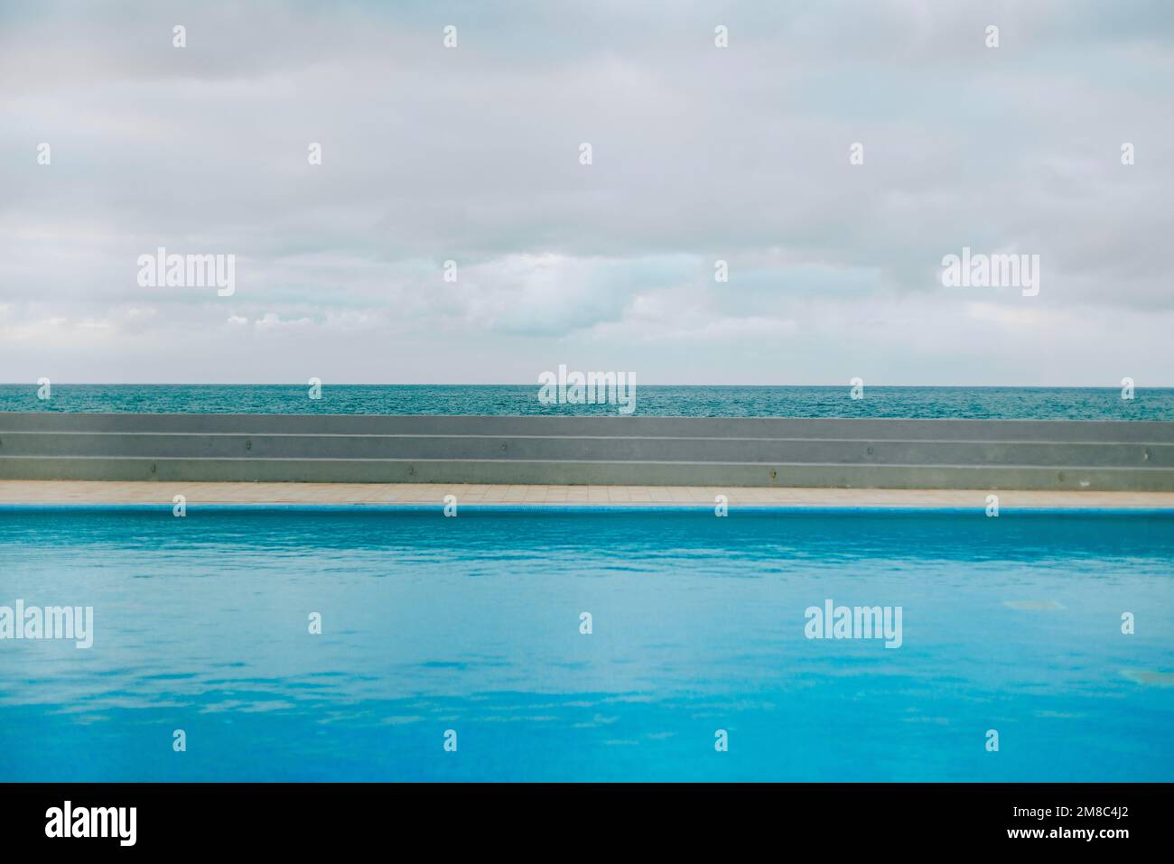 A beautiful shot of a pool with a barrier by the sea in Tenerife ...
