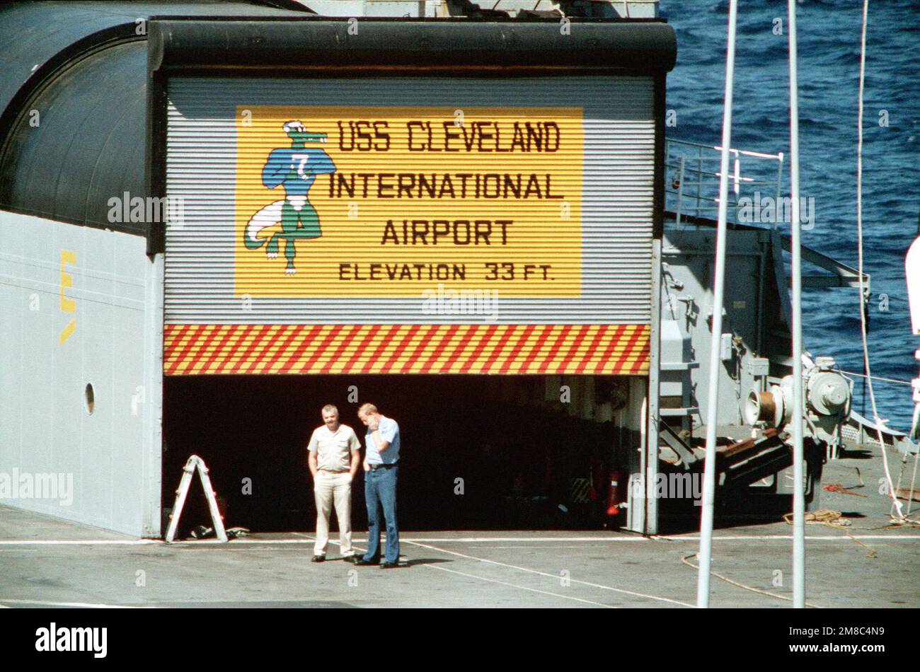 Navy personnel stand in front of the helicopter hangar on the ...