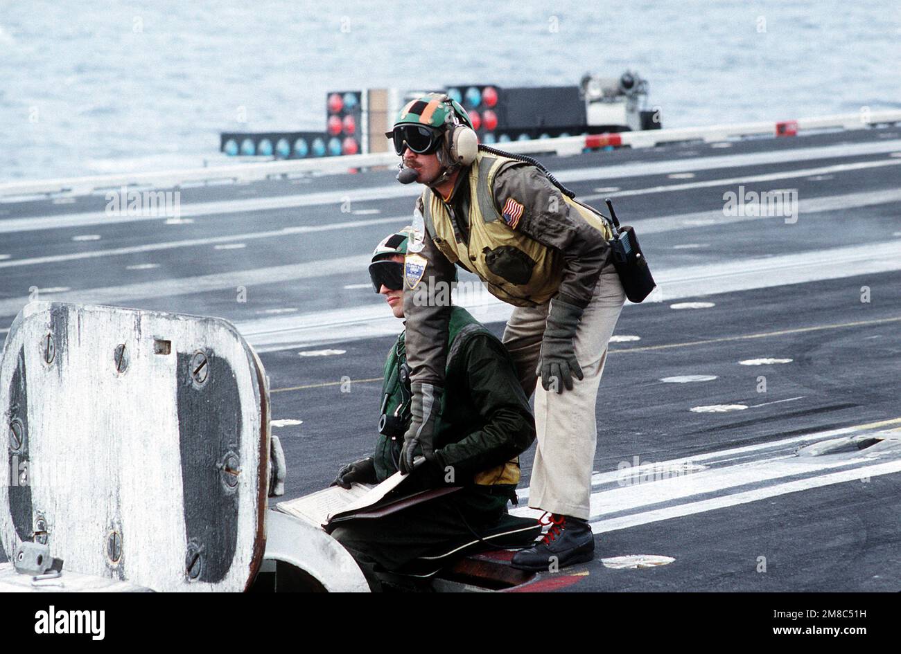 A catapult officer and a catapult crew member check last minute details ...