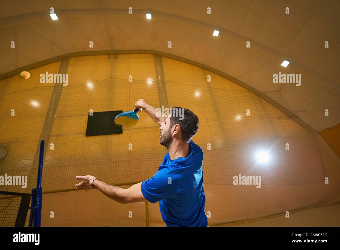 Man is hitting a tennis ball with a racket indoors Stock Photo - Alamy
