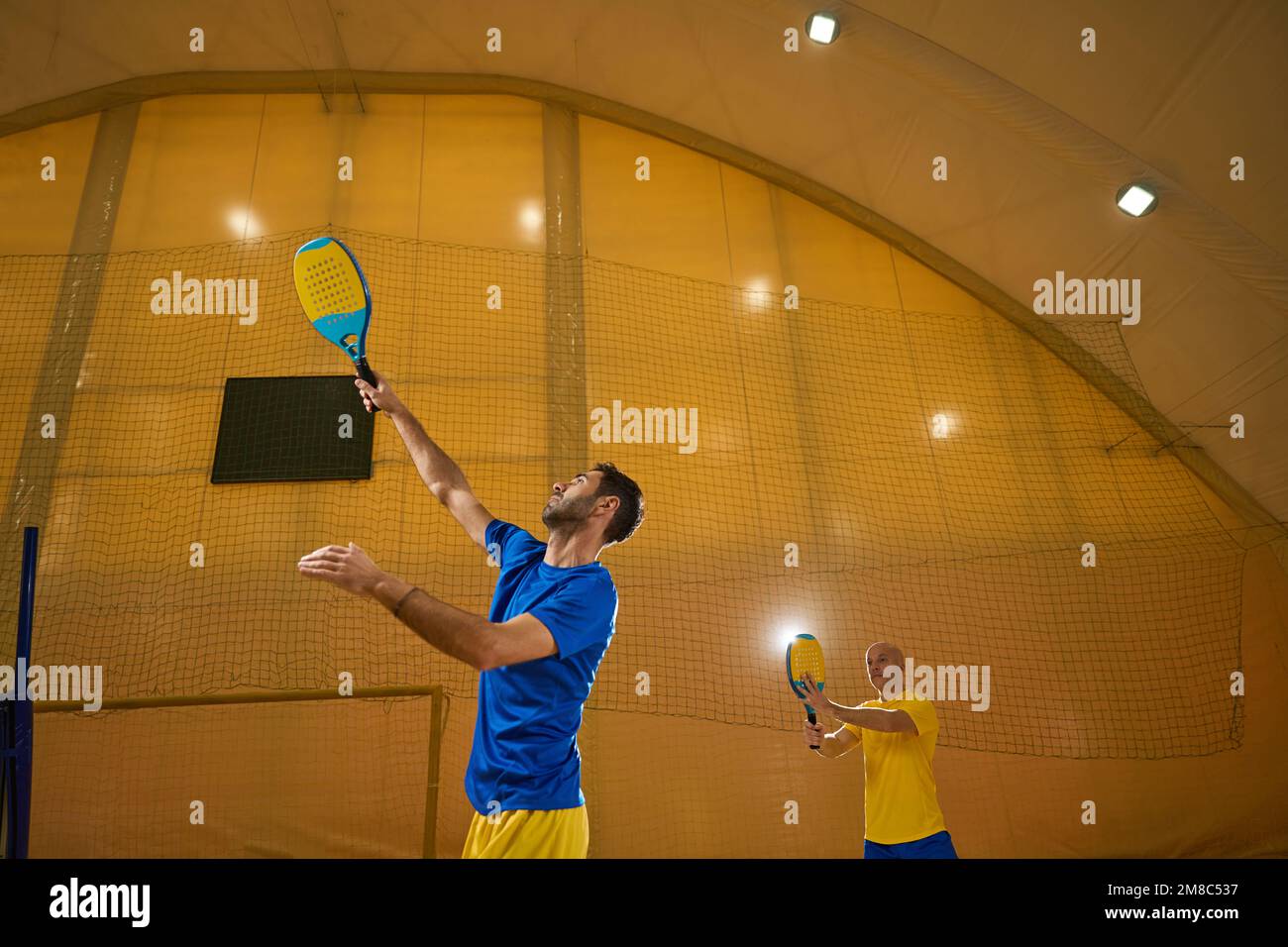 Two men are spending time in team playing frescoball indoors Stock ...