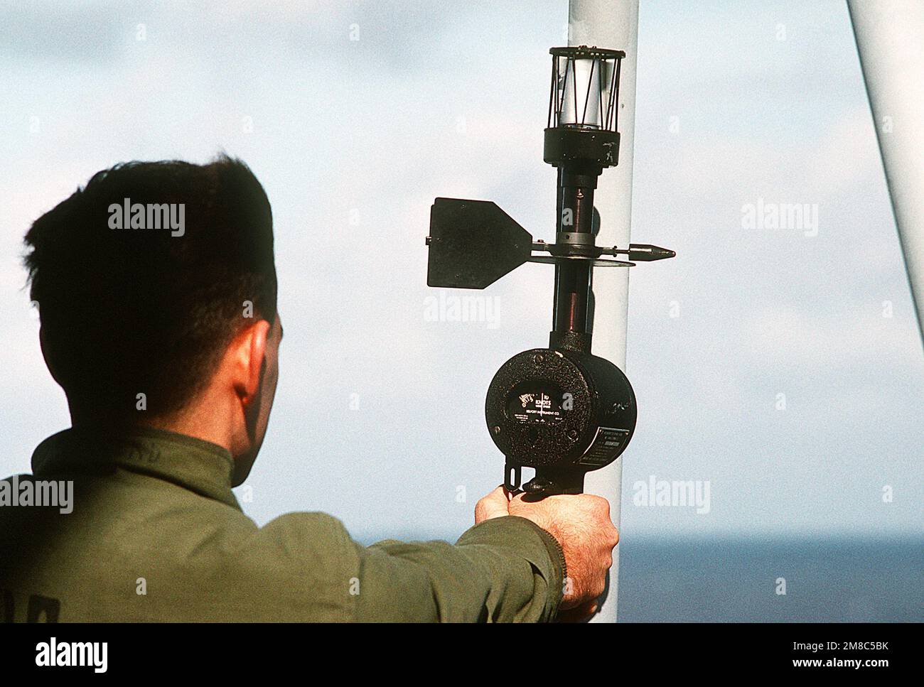 An aerographer's mate uses a hand-held anemometer (Wind Measuring Set ...