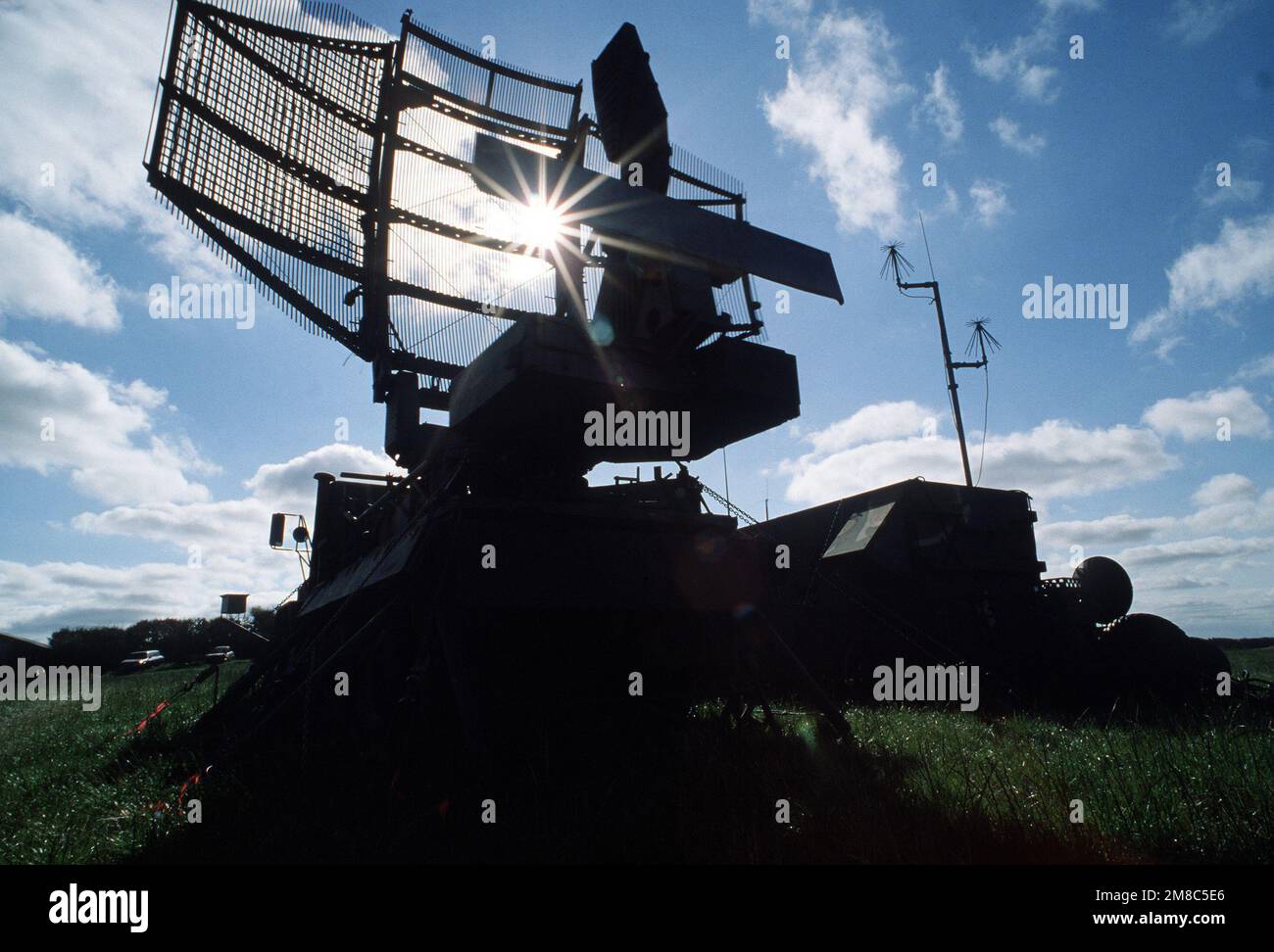 The antenna of an AN/TVS-43E search radar is silhouetted against the ...