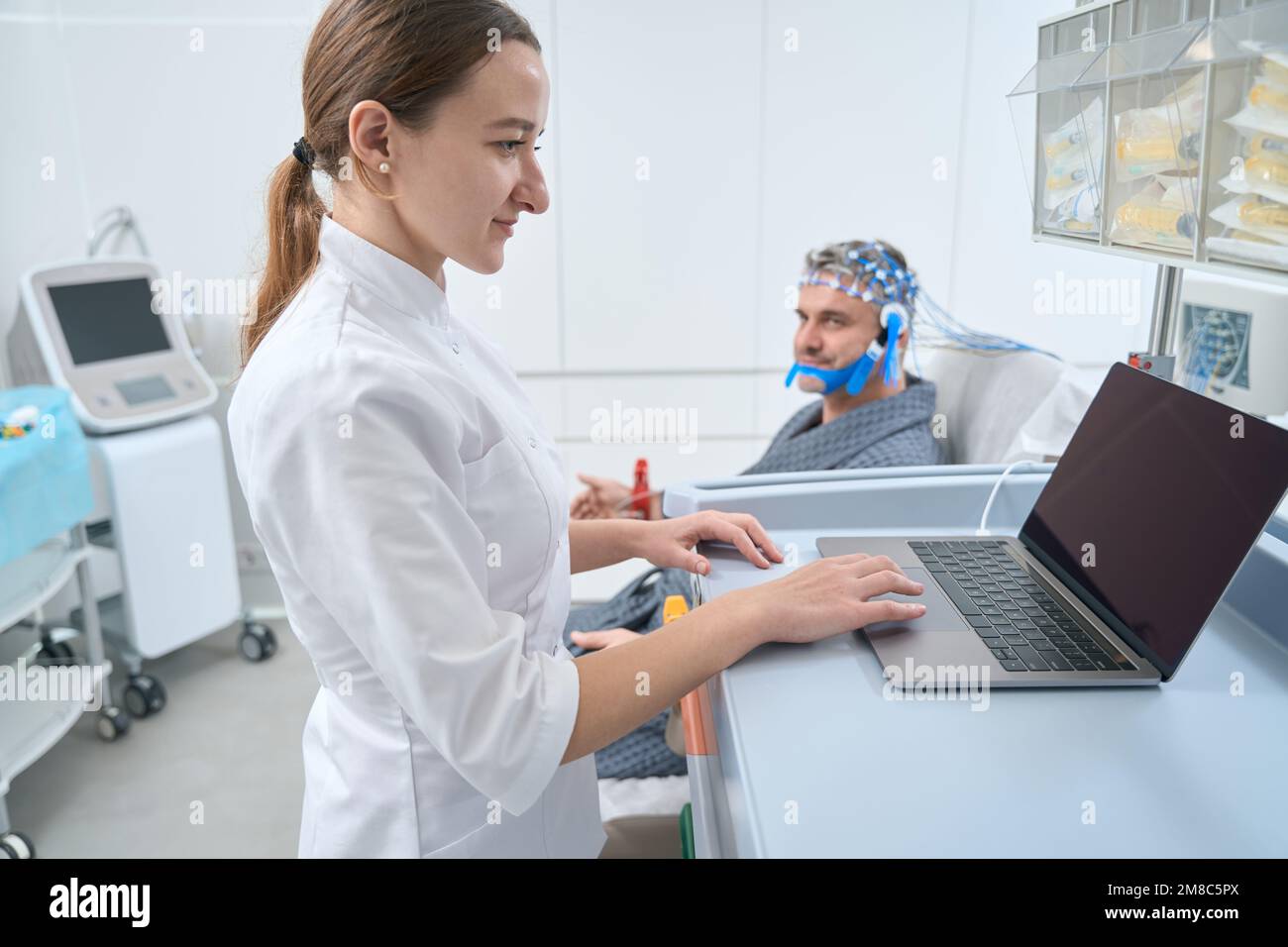 Woman diagnostician at the workplace conducts EEG ...