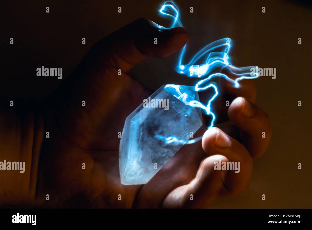 Rock crystal rod illuminated with light painting in hand Stock Photo ...