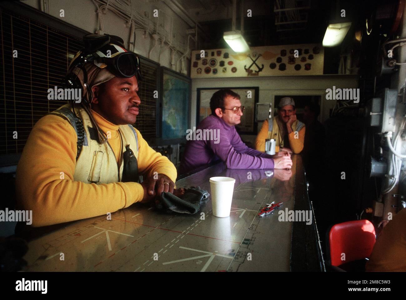 Crew members observe activity on deck from the flight control center ...