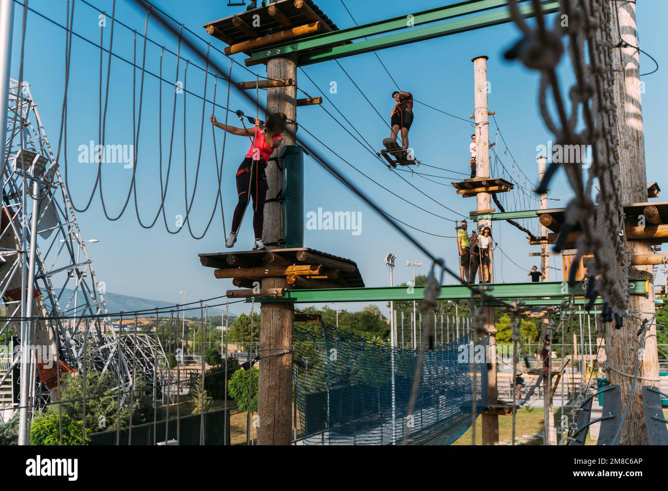Group of climbers doing the courses in the adventure park with ease Stock Photo - Alamy