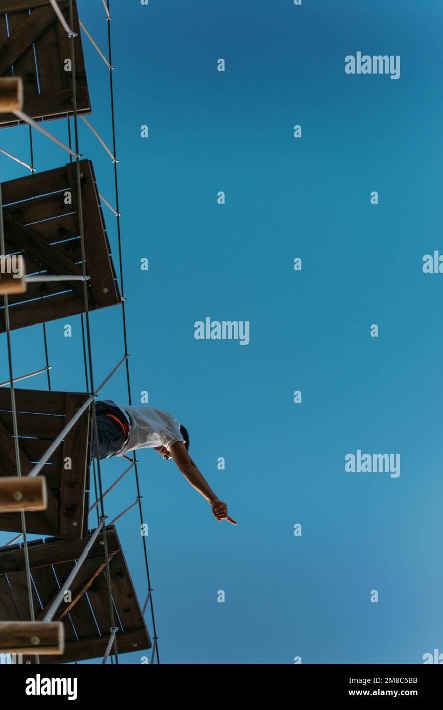 Adult man pointing at something high up in the air whilst standing on ...
