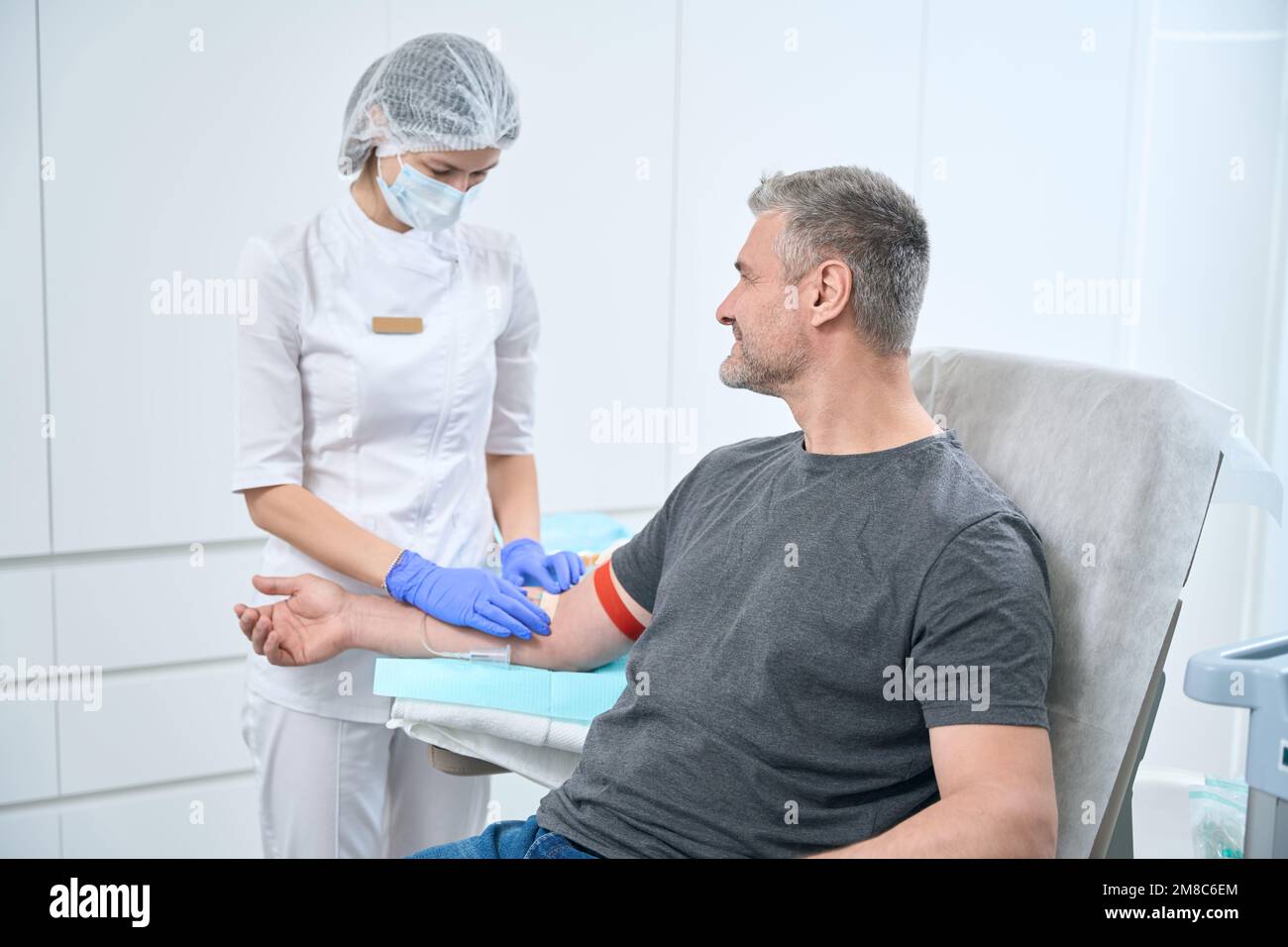 Smiling patient takes a blood test from a vein Stock Photo - Alamy