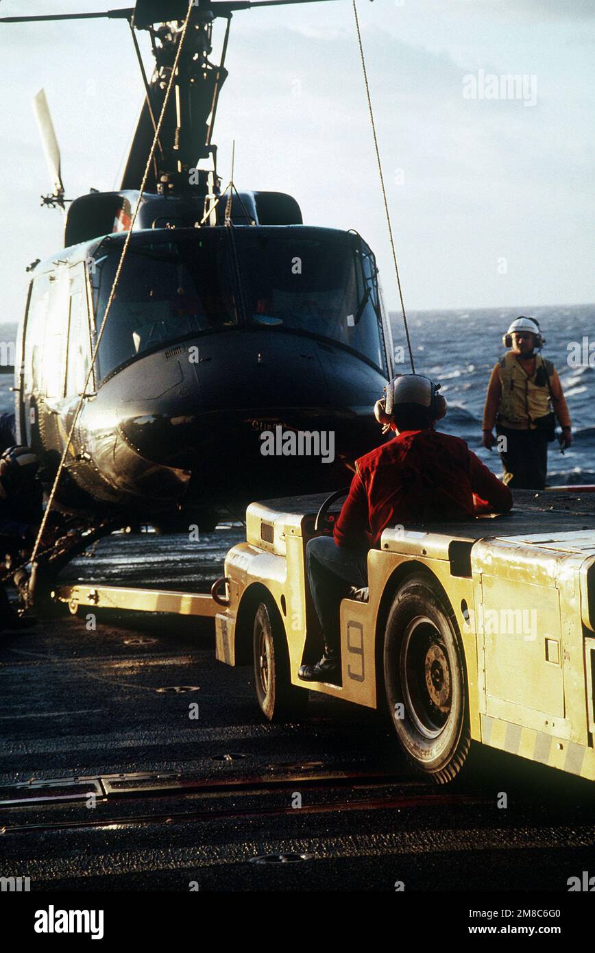 An MD-3A tow tractor is used to maneuver a UH-1N Iroquois helicopter on ...