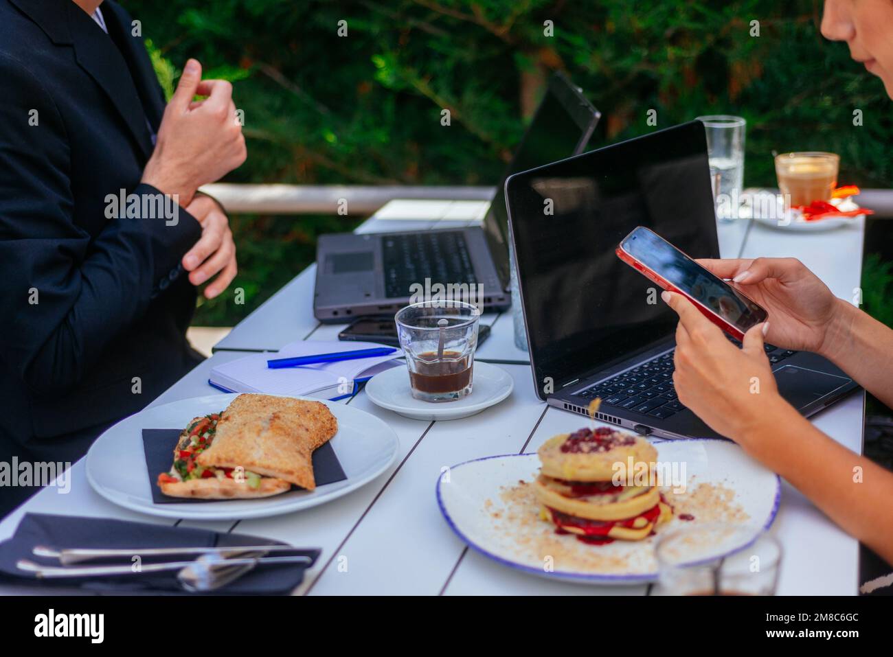 A male business person is working on his lap top while his female ...