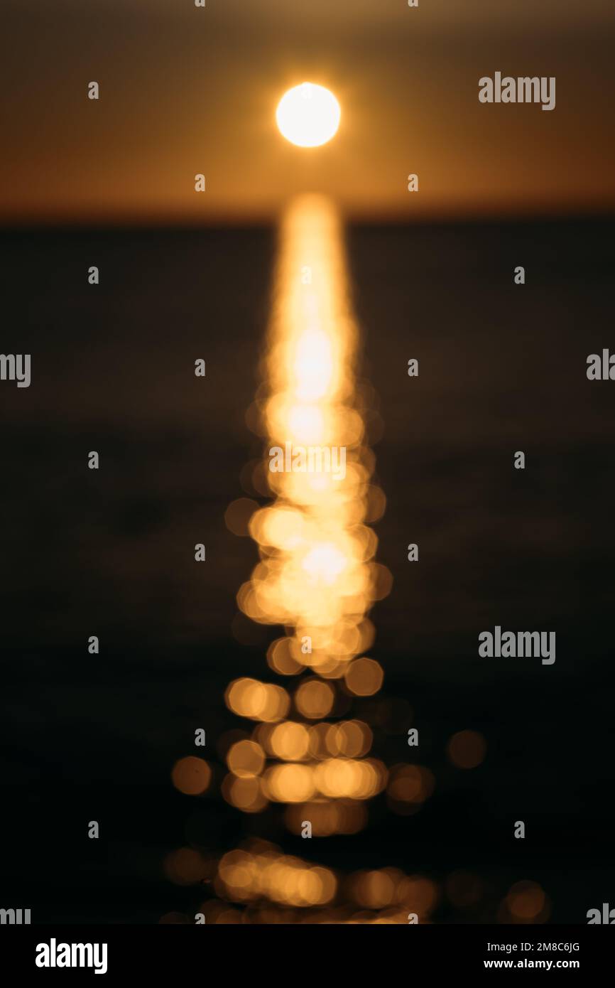 On a blurry abstract blurred sunset background, a bright yellow sun ...