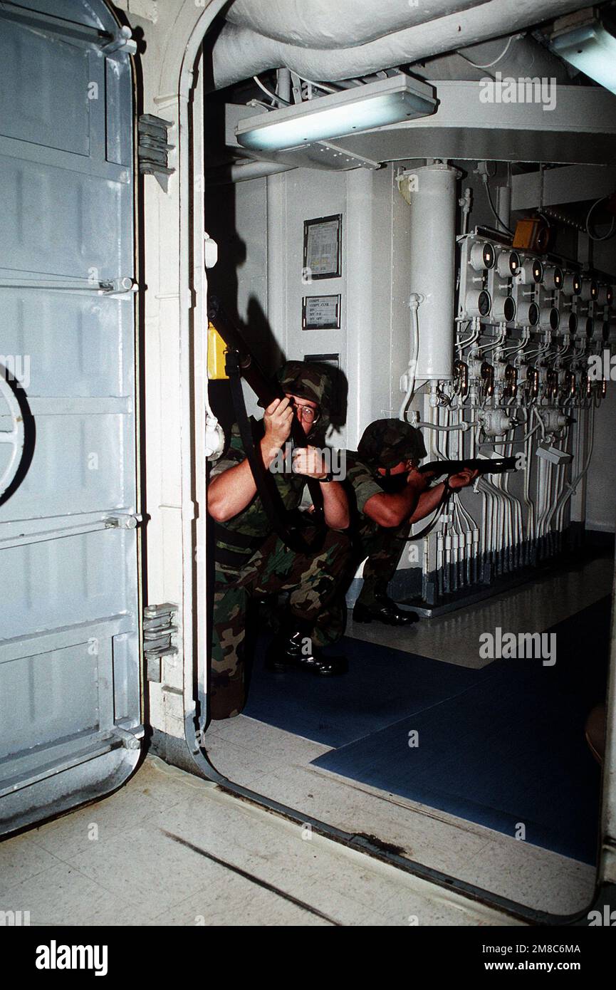 Armed with shotguns, two members of the ship's Marine detachment each ...