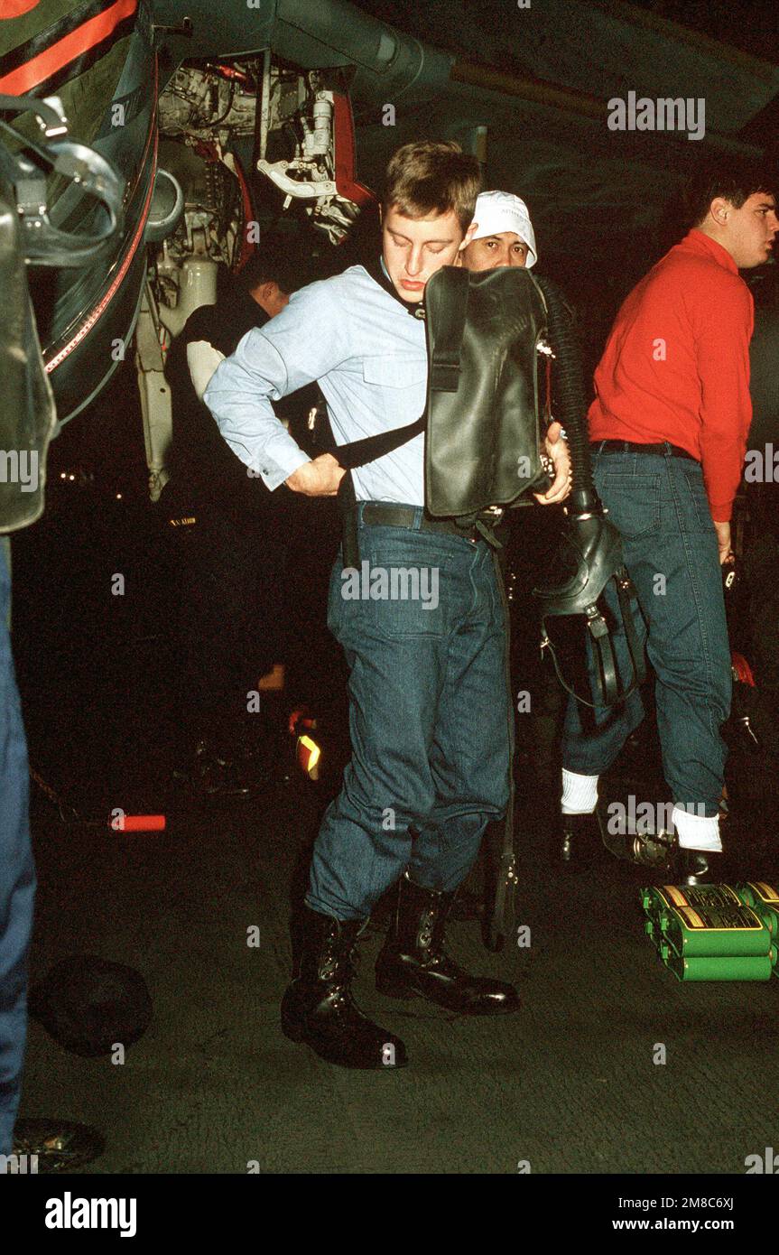 A sailor straps on his oxygen breathing apparatus (OBA) prior to a ...