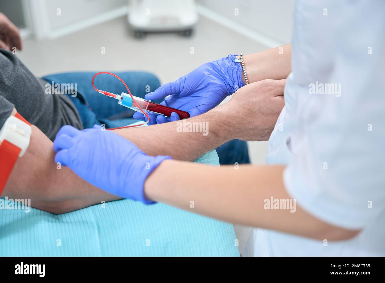 Nurse takes a blood sample from patient in medical clinic Stock Photo ...