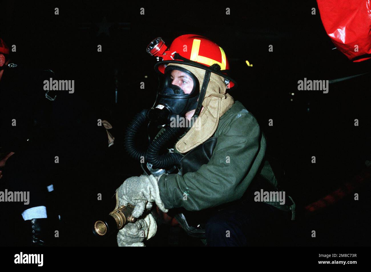 A hose team leader wearing an oxygen breathing apparatus (OBA) waits ...