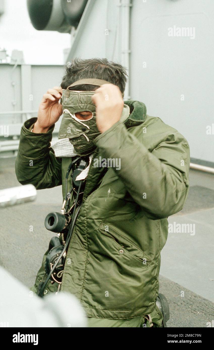 A sailor on the aircraft carrier USS CONSTELLATION (CV 64) dons a cold ...