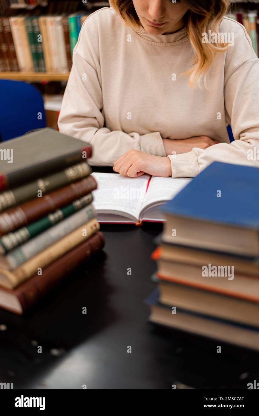 Beautiful girl studying and reading books in a library Stock Photo - Alamy