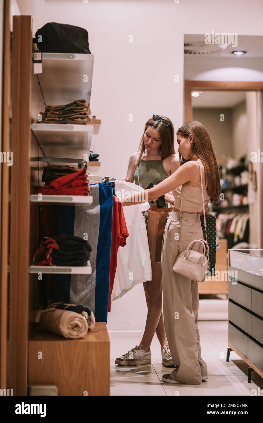 Two beautiful girls trying to find something for their boyfriends in ...