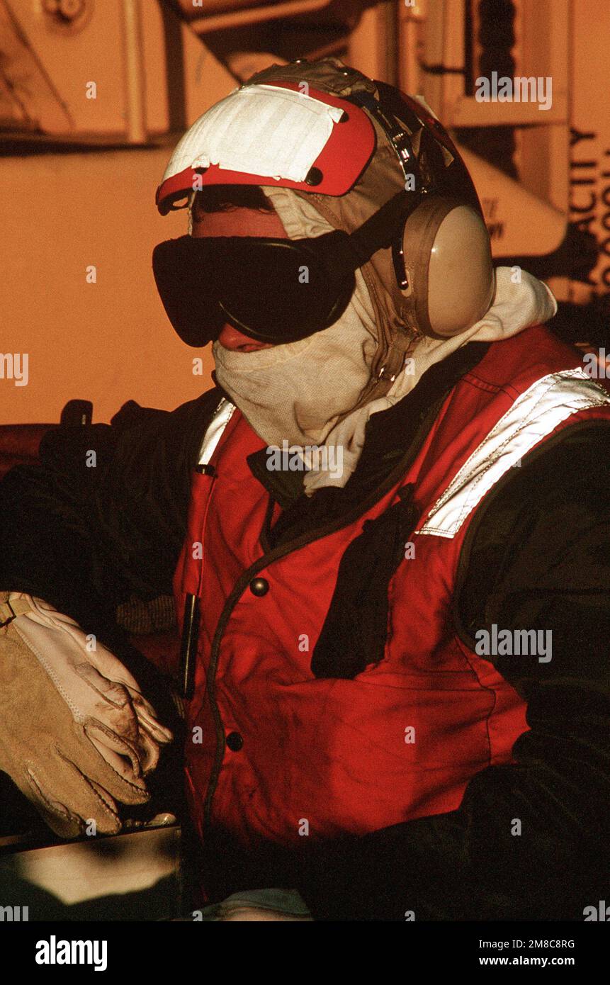 A flight deck crewman takes a moment to stand out of the weather during ...