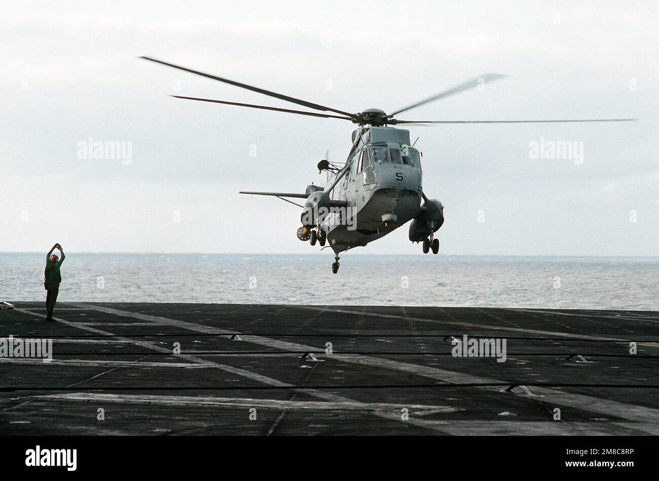 An SH-3 Sea King helicopter takes off from the flight deck of the ...