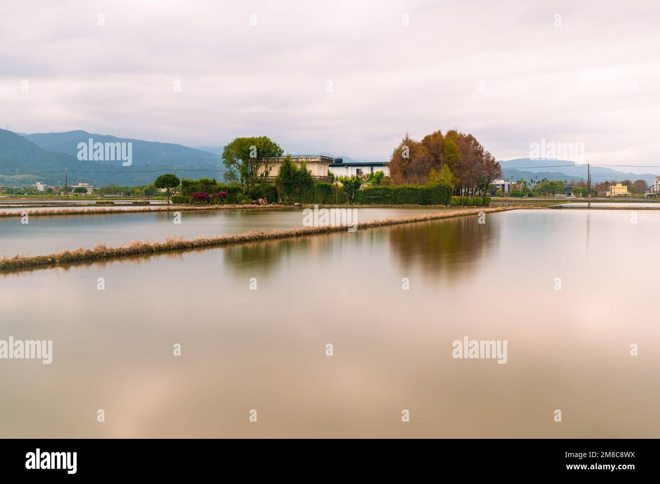 Beautiful countryside landscape at dusk. House, water field and ...