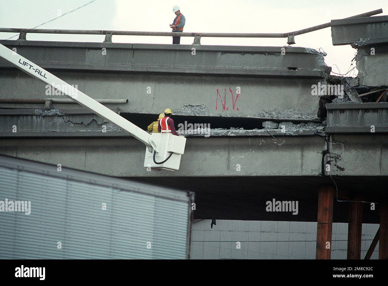 Rescue personnel are lowered by crane to a collapsed section of ...