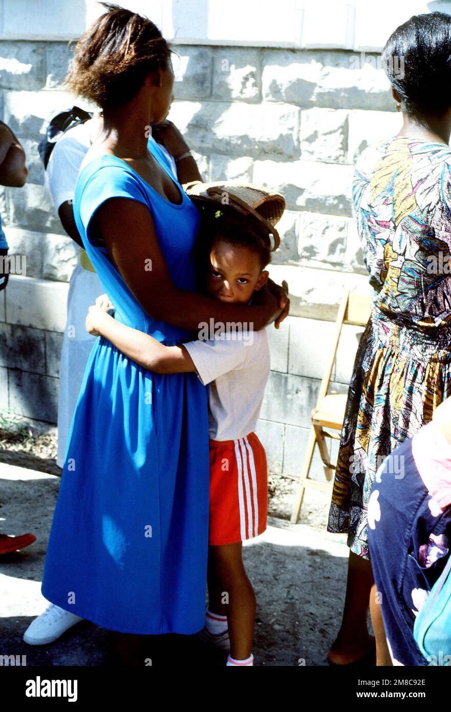 A mother and child stand in line outside a food distribution center set ...