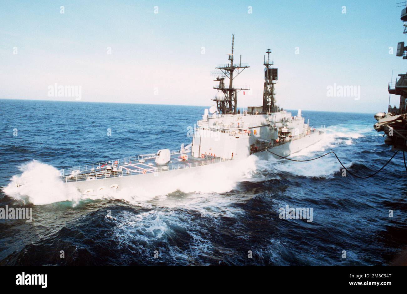 The guided missile destroyer USS KIDD (DDG-993) takes white water over ...