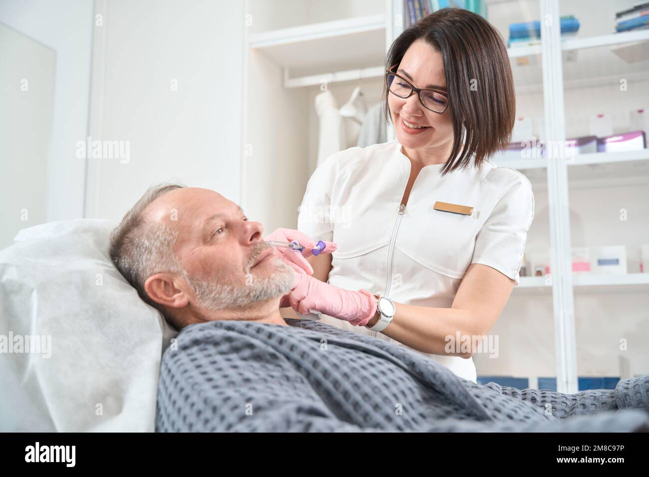 Elderly patient receives collagen injections in an aesthetic medicine ...