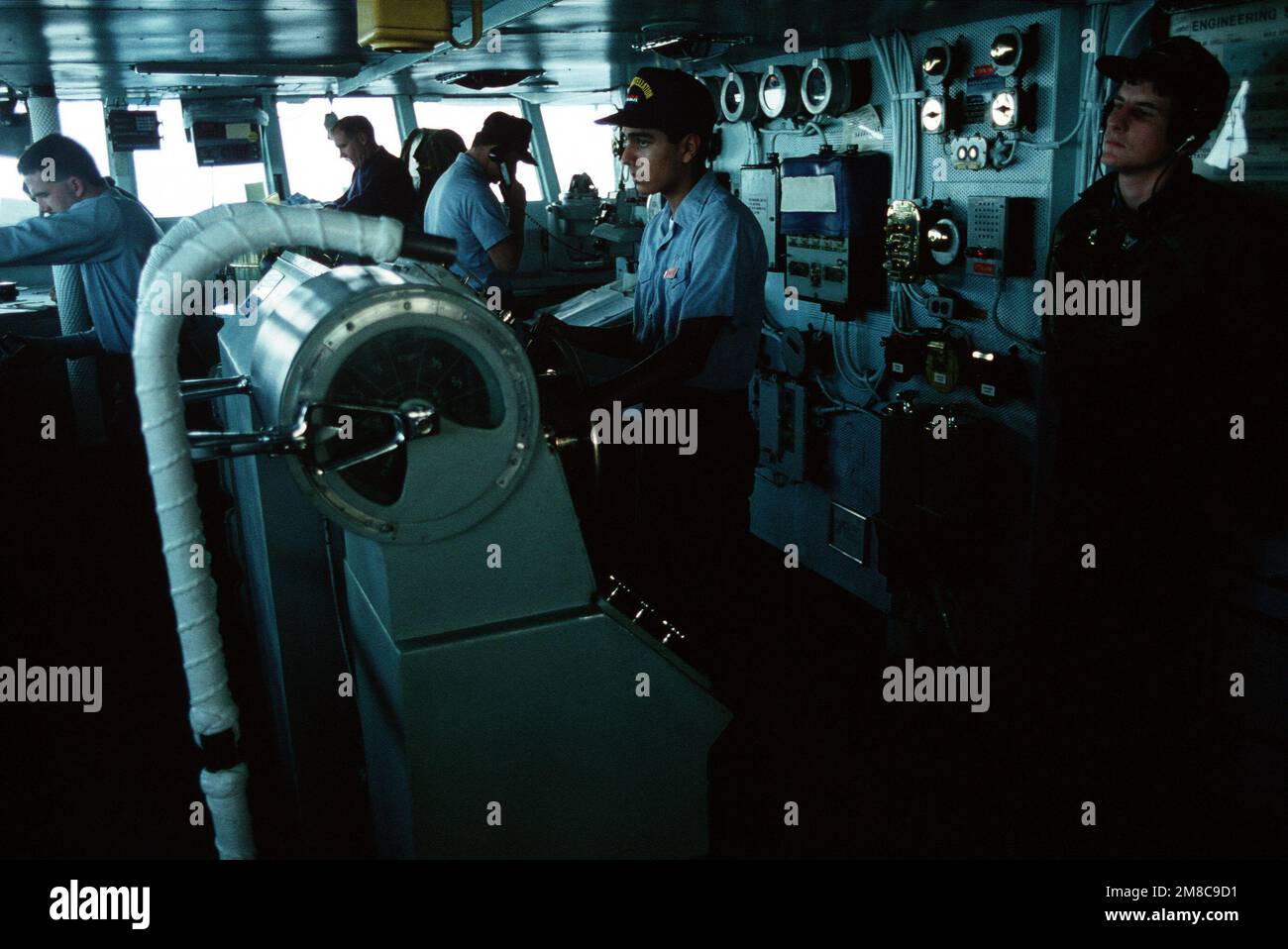 A sailor mans the helm on the bridge of the aircraft carrier USS ...