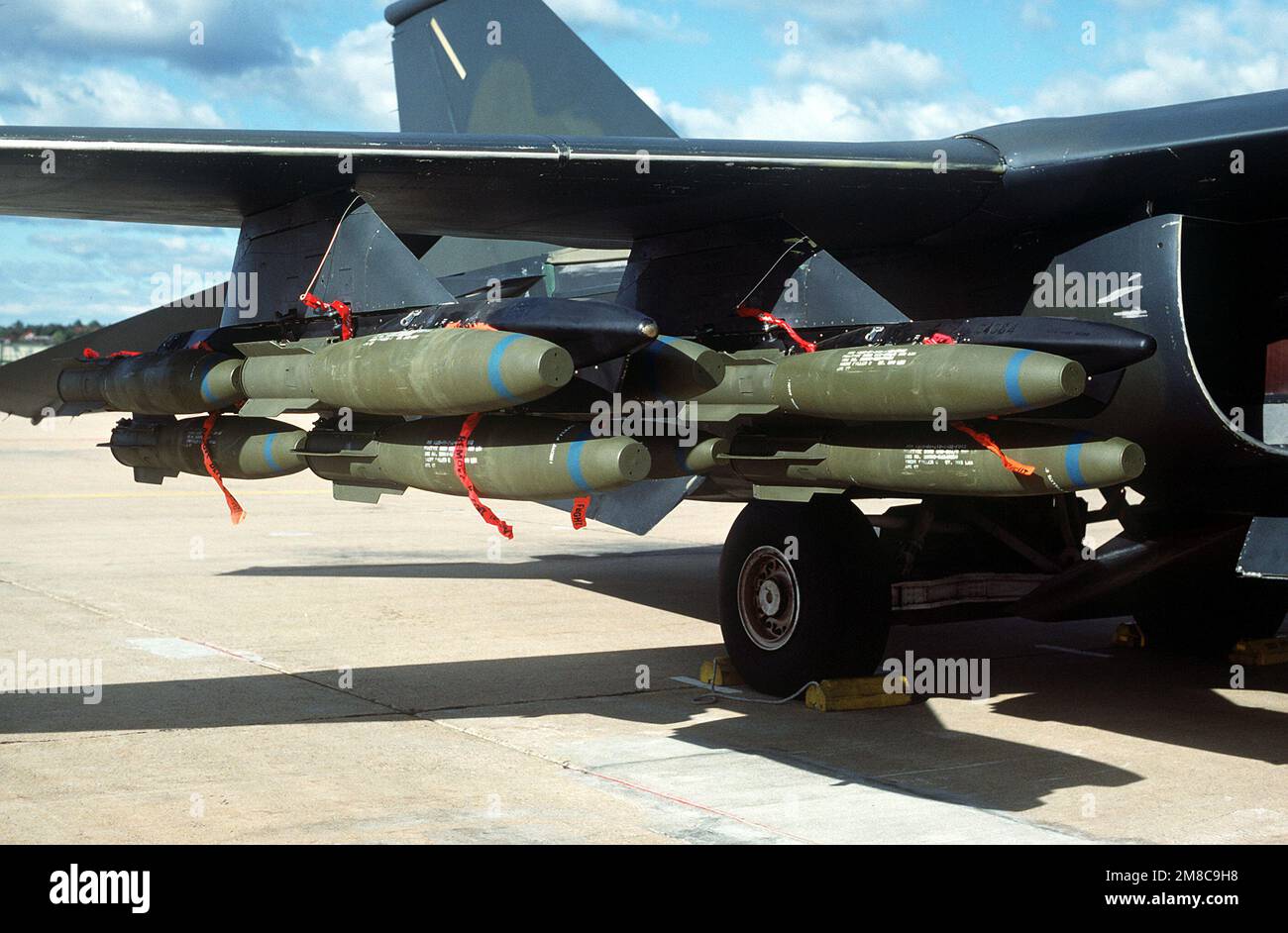 A view of ten BDU-50 practice bombs mounted on pylons beneath the left ...