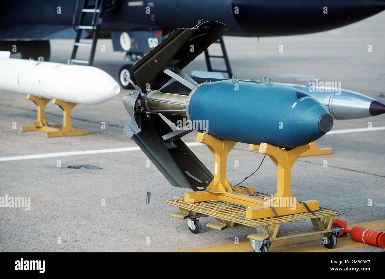A view of a Mark 117 750-pound high-drag bomb, foreground, being shown ...
