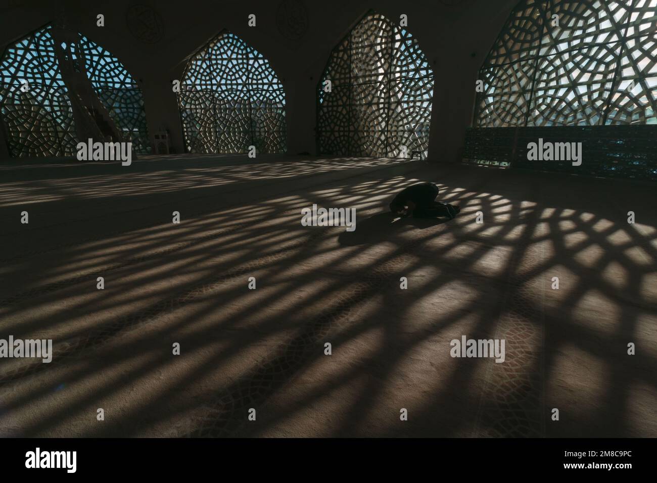 Islamic photo. Muslim man praying in a mosque. Shadows of window on the ...
