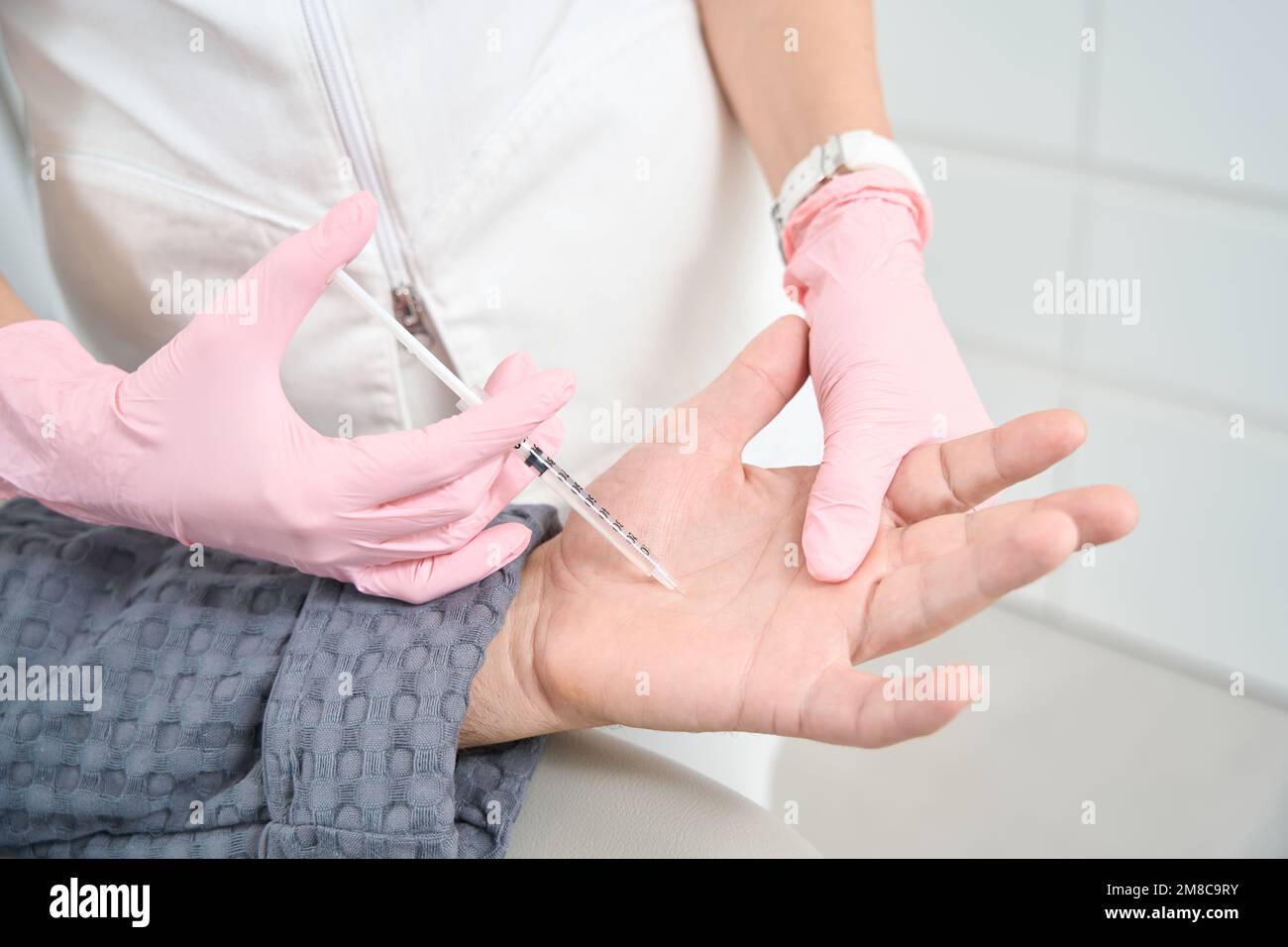 Doctor makes an injection in patient palm to eliminate sweating Stock ...